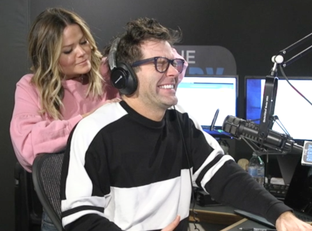 Amy of The Bobby Bones Show Excitedly Pops Bobby Bones' Back Pimple ...